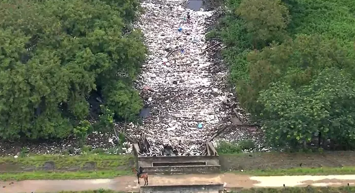 Man Walks On River Choked With Garbage In Brazil