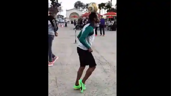 Man Balancing A Football On His Head While Moonwalking