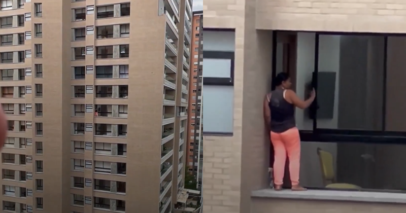 Woman Cleans Window Of High-rise Building While Standing On Ledge