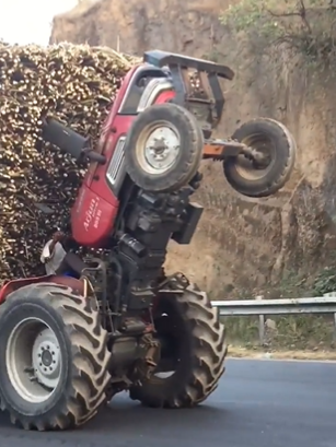 Tractor Moves On Busy Road With Its Front Wheels Up